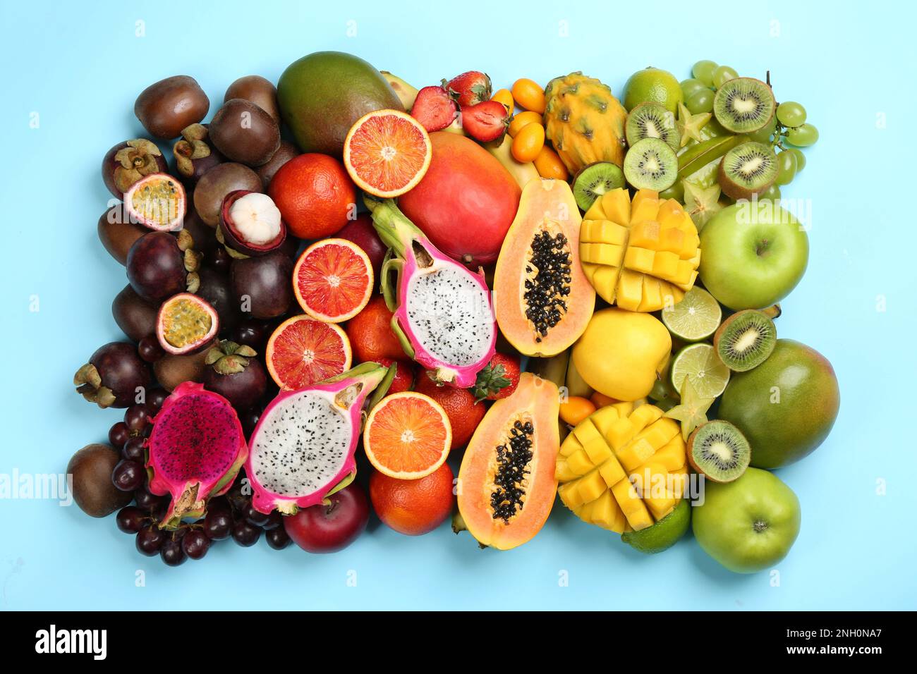 Many different delicious exotic fruits on light blue background, flat ...