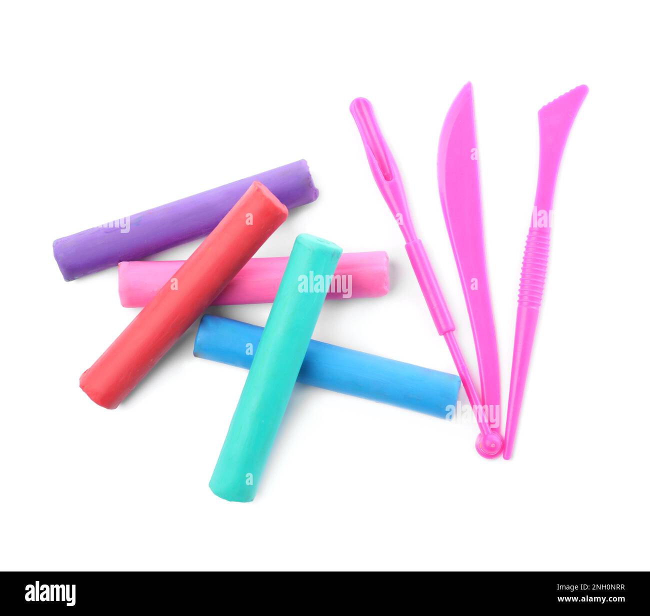 Many different colorful plasticine pieces and sculpting tools on white ...