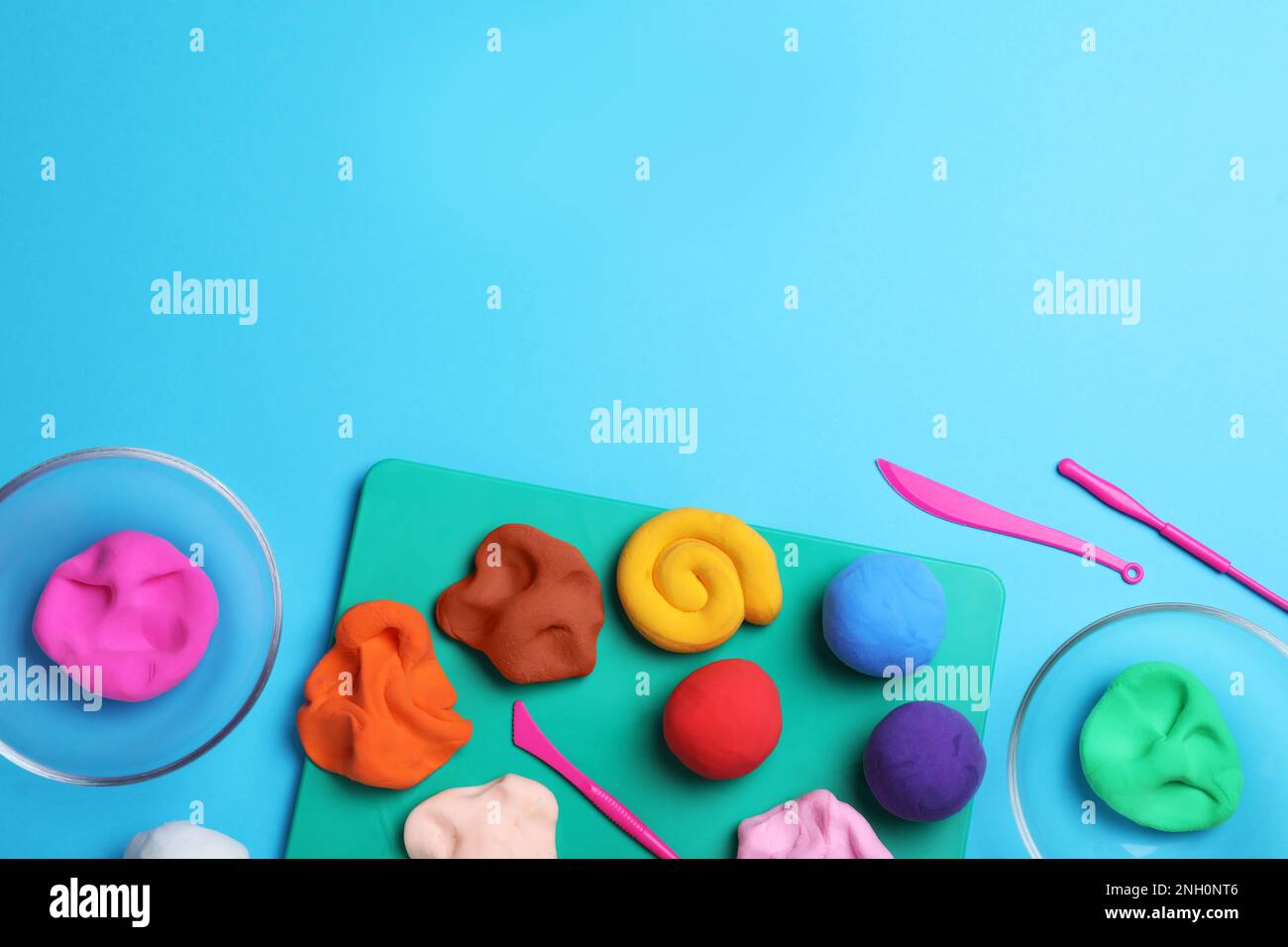 Flat lay composition with colorful plasticine on light blue background ...