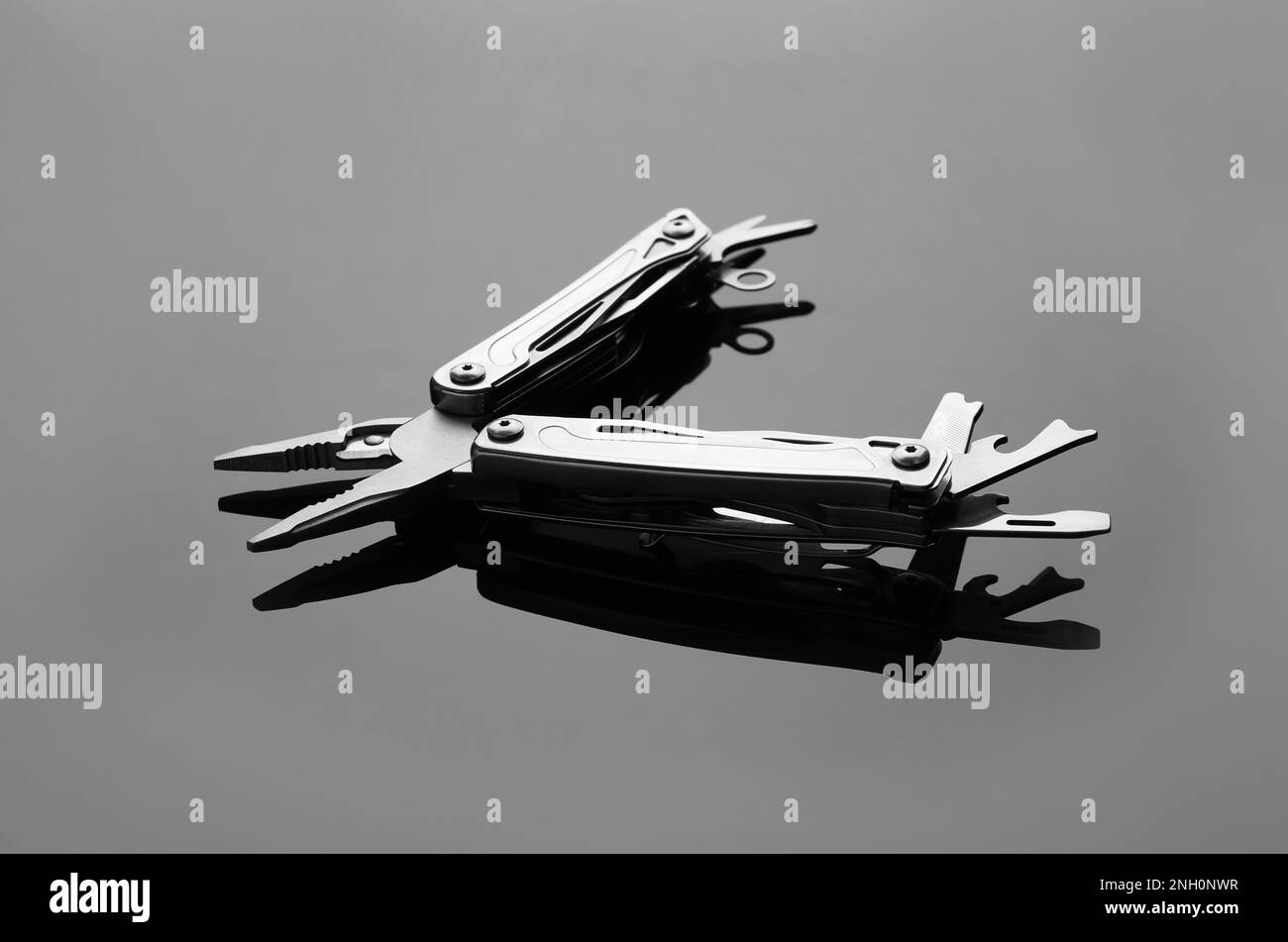 Compact portable metallic multitool on grey table Stock Photo - Alamy
