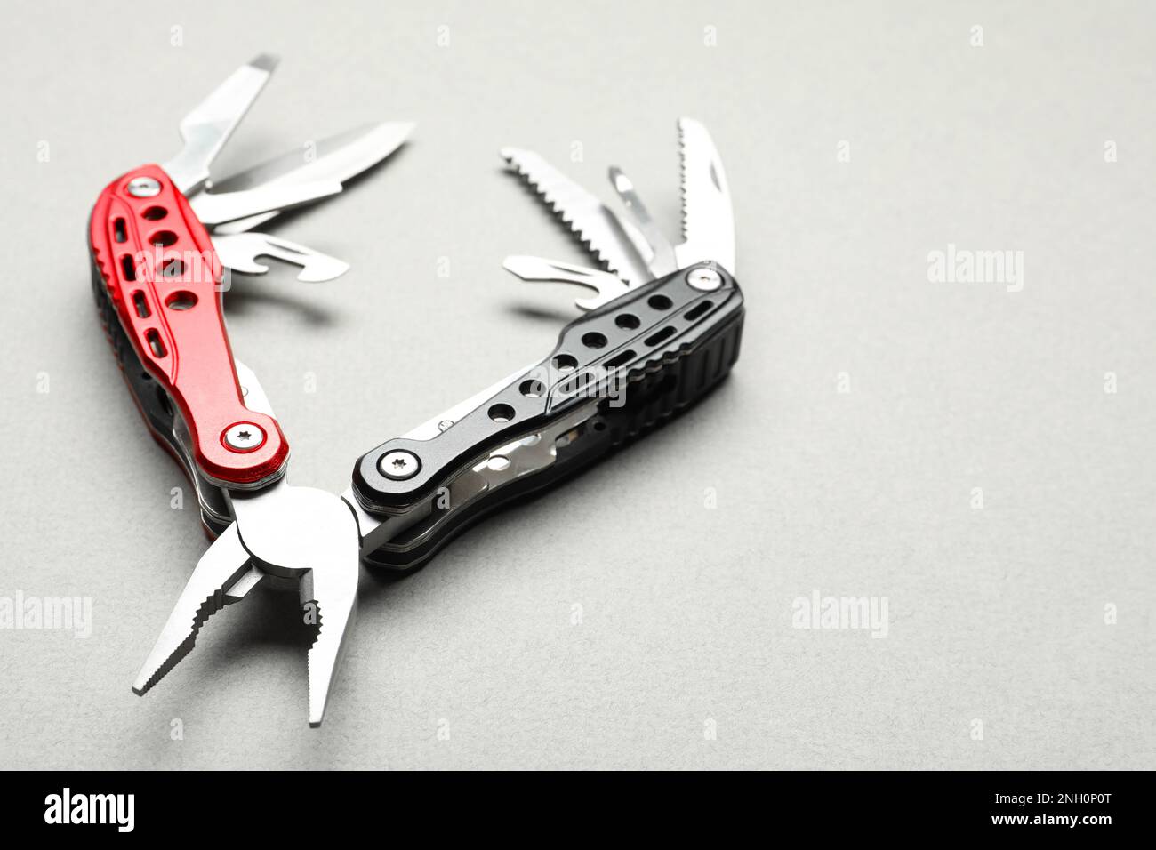 Compact portable multitool on light grey background, closeup. Space for ...