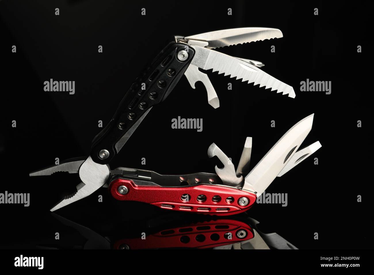 Compact portable colorful multitool on black background Stock Photo - Alamy