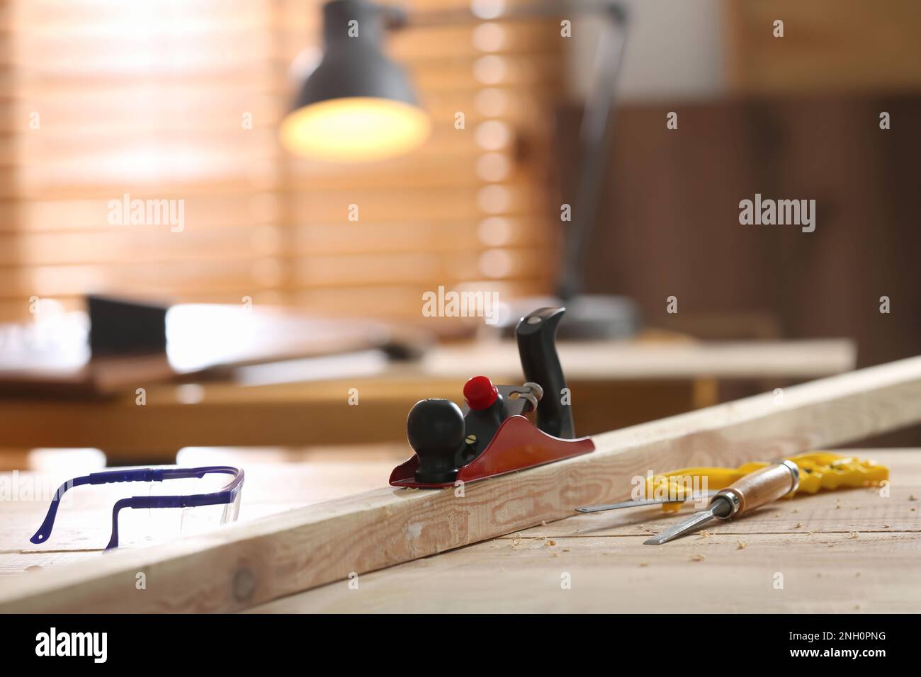 Different carpenter's tools and wooden bar on table in workshop. Space ...
