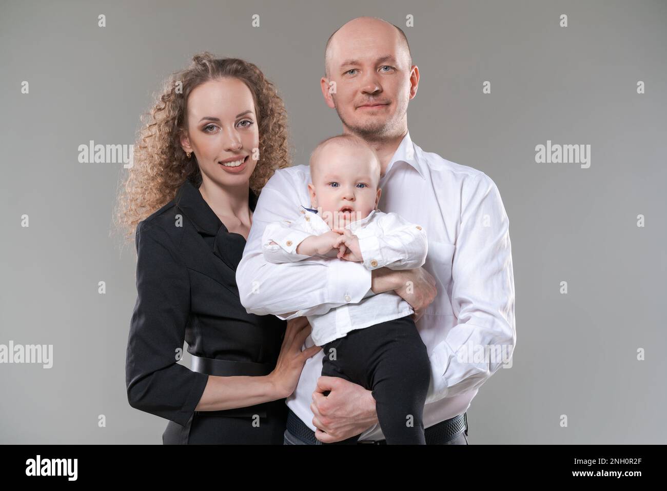 Young family photographed with small child. Father holds child in his ...