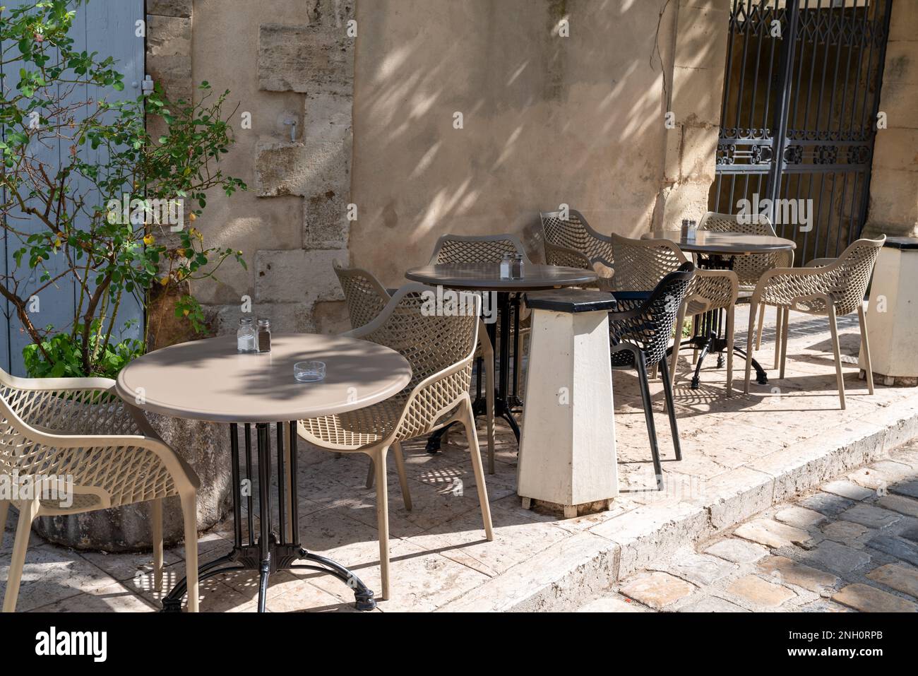 Empty retro tables and chairs on a outdoor cafe terrace in Avignon ...