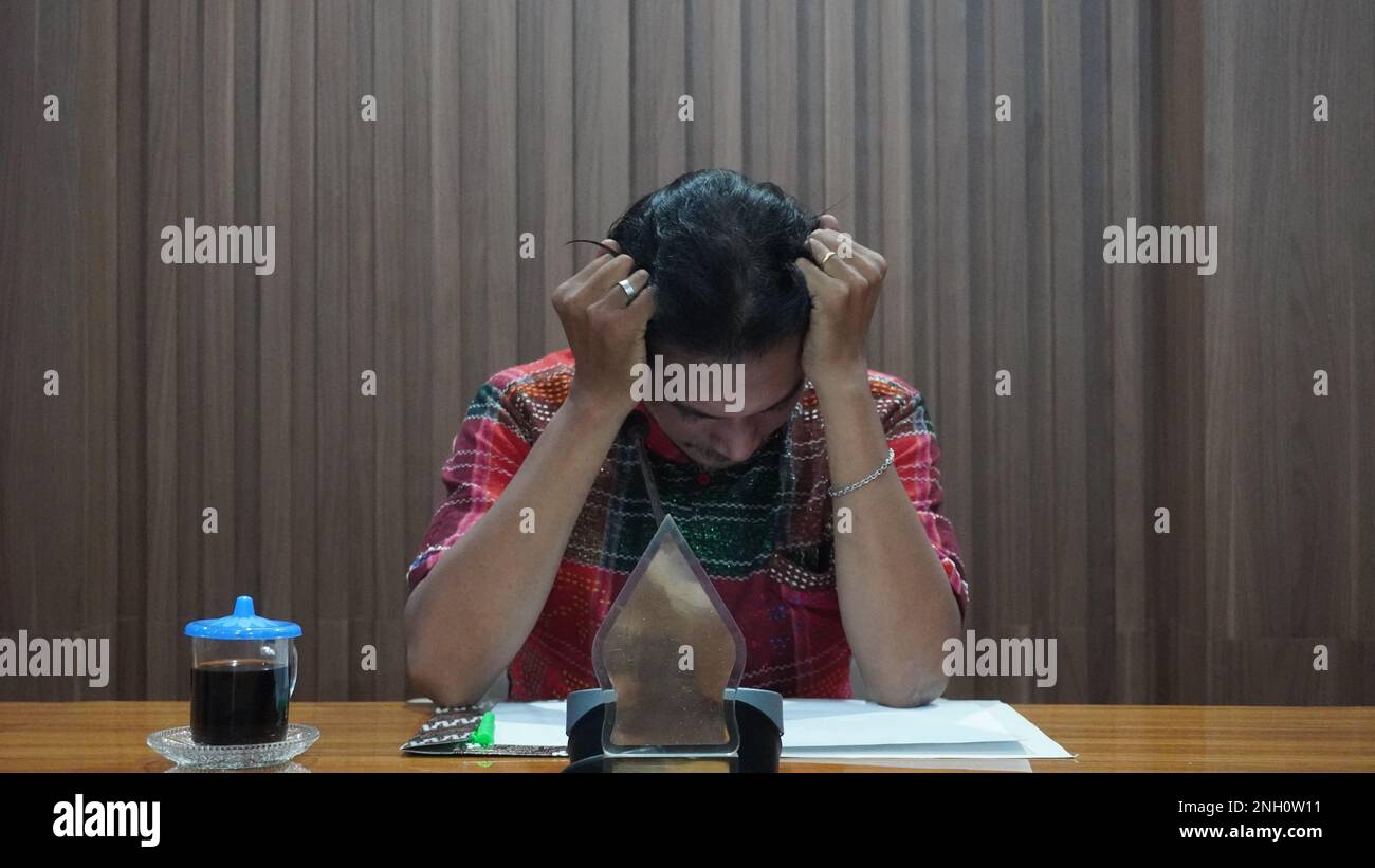 stressed and dizzy business man holding head during meeting Stock Photo ...