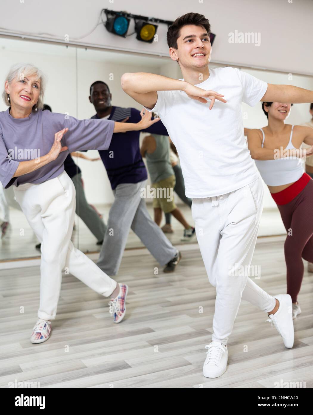 Caucasian man rehearsing modern dance with group in dance school Stock ...