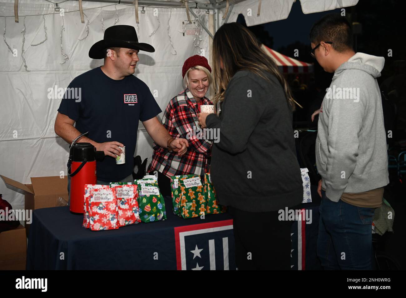 The USO volunteers hand out hot cocoa and goody bags to Airmen and ...