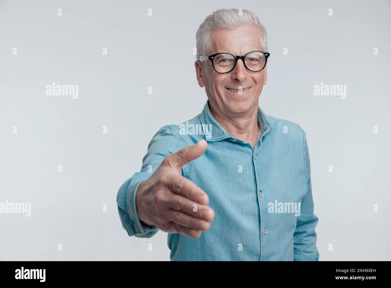 old man in his 60s with glasses shaking hand gesture and introducing ...