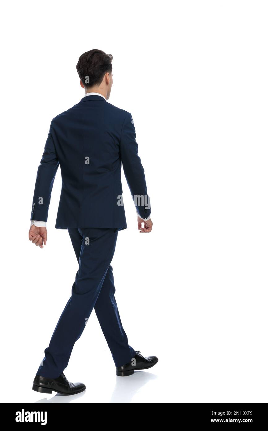 young businessman walking on his own path, wearing a suit and tie ...