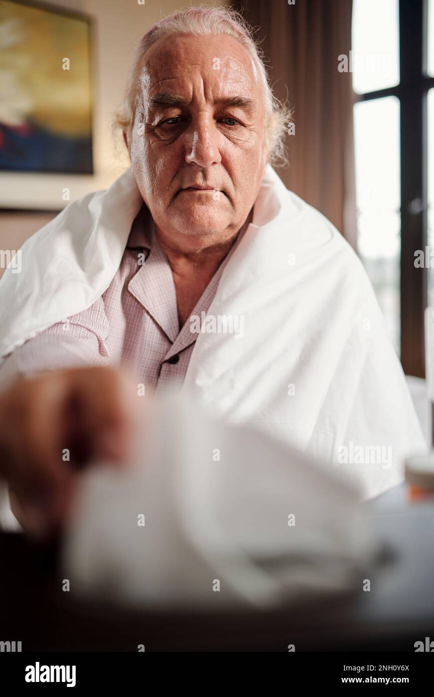 Sick aged man taking paper tissue to blow his nose Stock Photo - Alamy