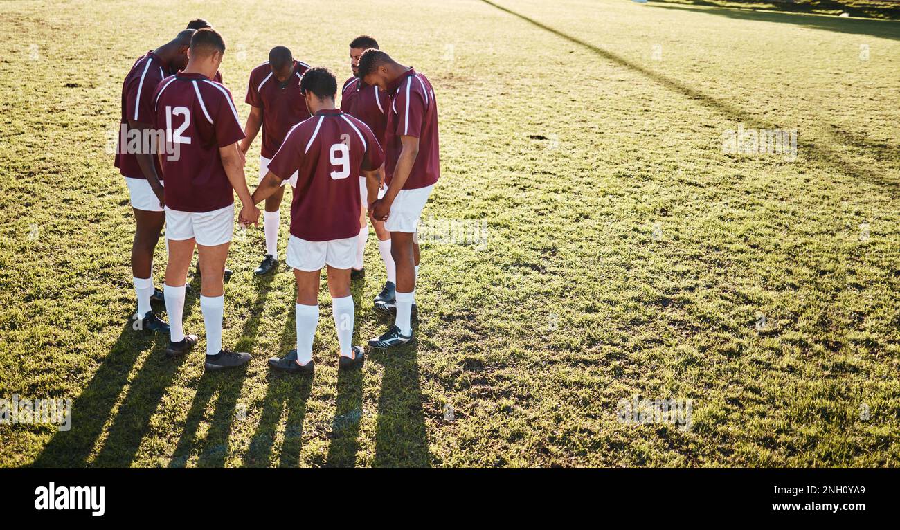 Men, huddle and team holding hands praying on grass field for sports ...