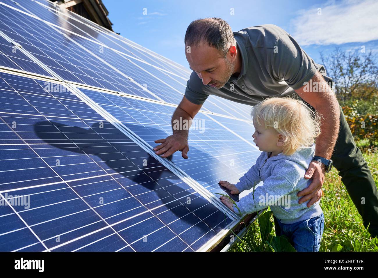 Man showing little child the solar panels during sunny day. Father ...