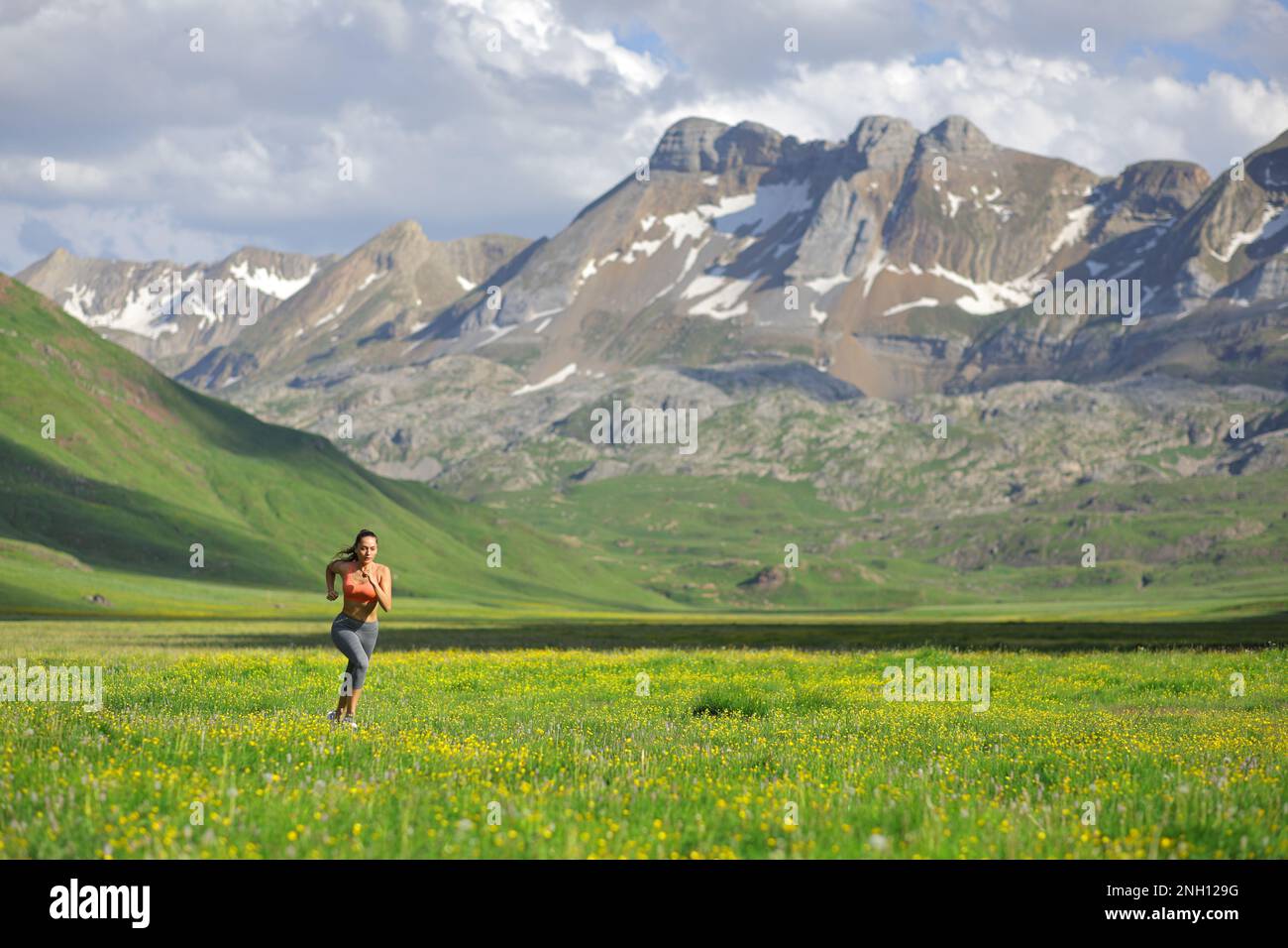 Full body portrait of a runner running in a beautiful mountain with ...