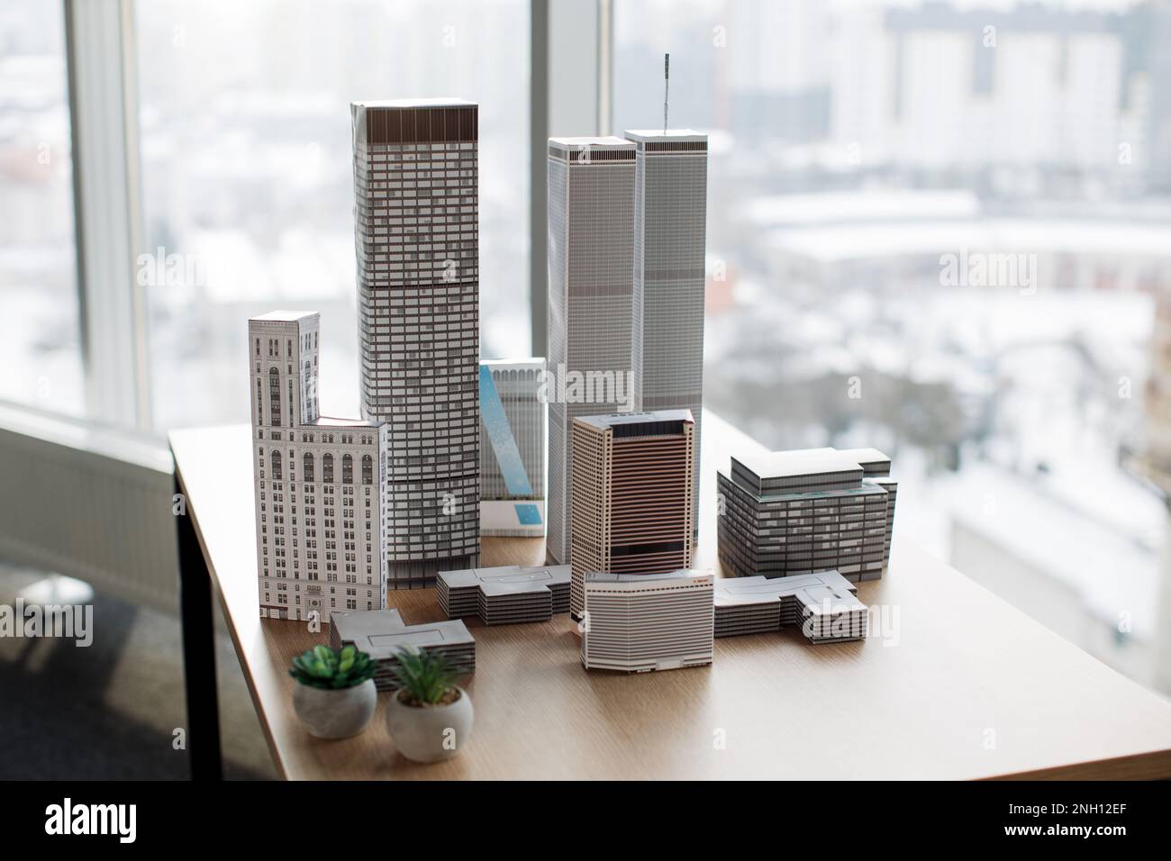 Table with white architectural scale cardboard model of building ...