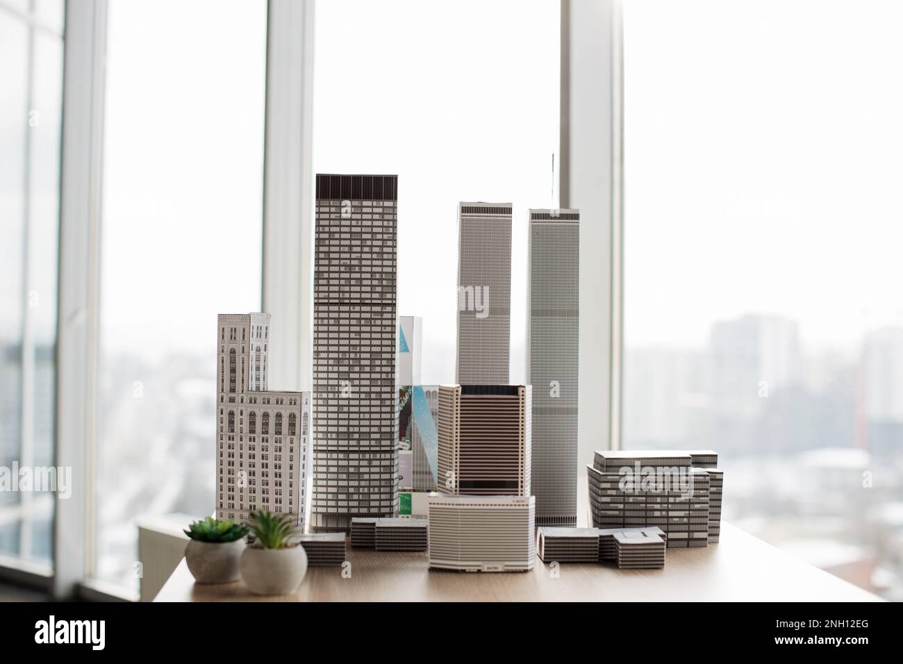 Table with white architectural scale cardboard model of building ...