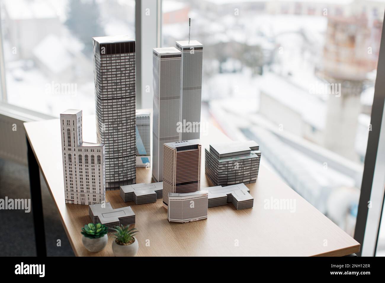 Table with white architectural scale cardboard model of building ...