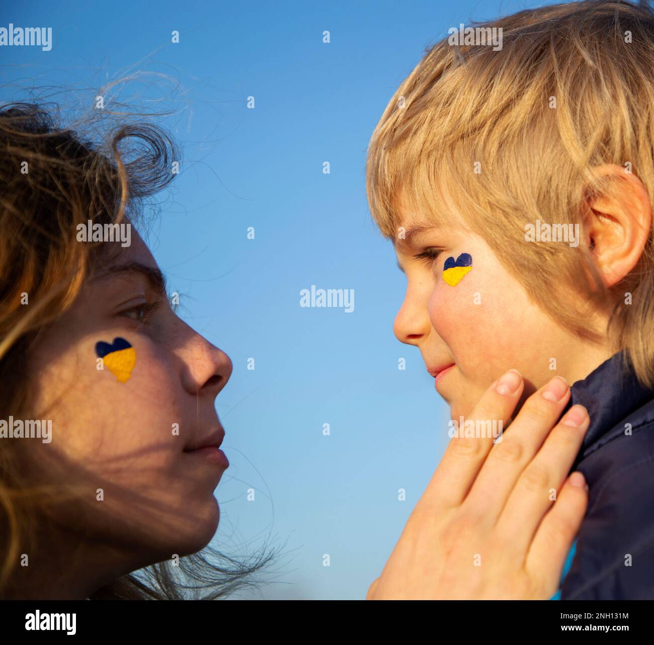 close-up of the face of young woman and little boy, heart in colors of ...