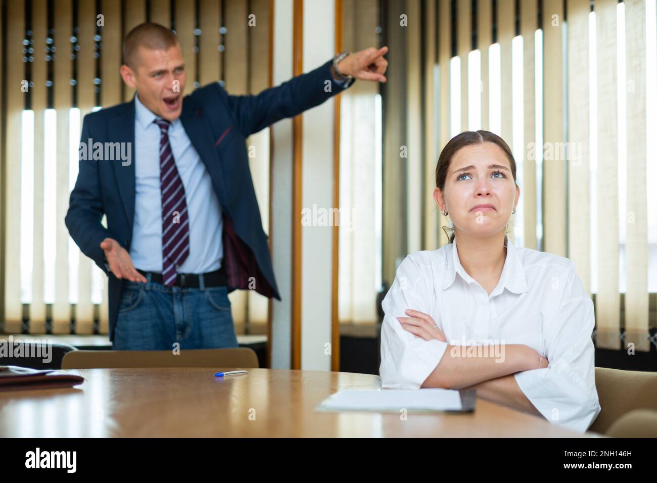 Emotional young boss berates his secretary girl in the conference room ...