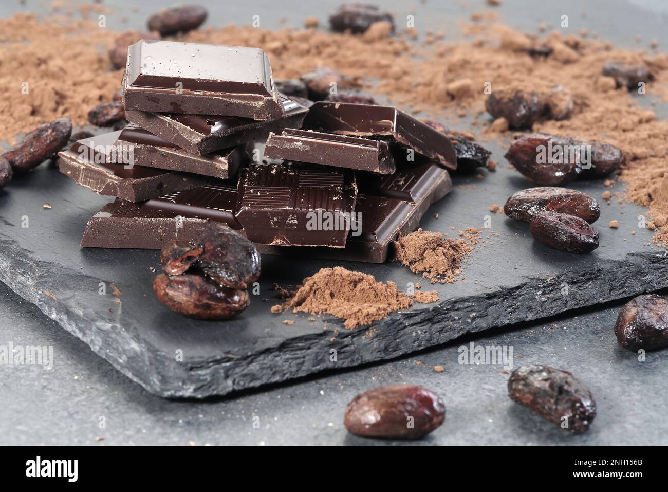 Broken dark chocolate and cocoa beans on a table Stock Photo - Alamy