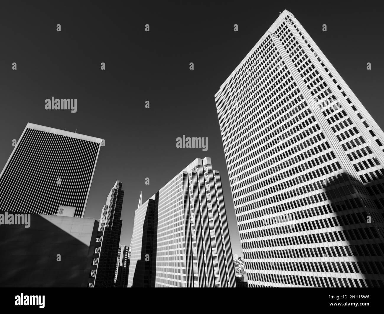 View looking up at monotone skyscrapers lit by morning sunshine and ...