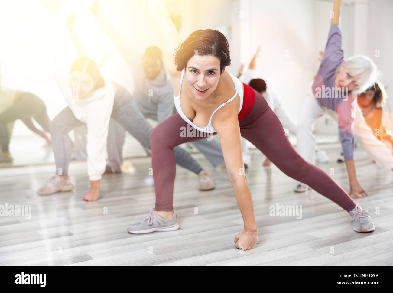 Group of active people performing a stretching exercise Stock Photo - Alamy