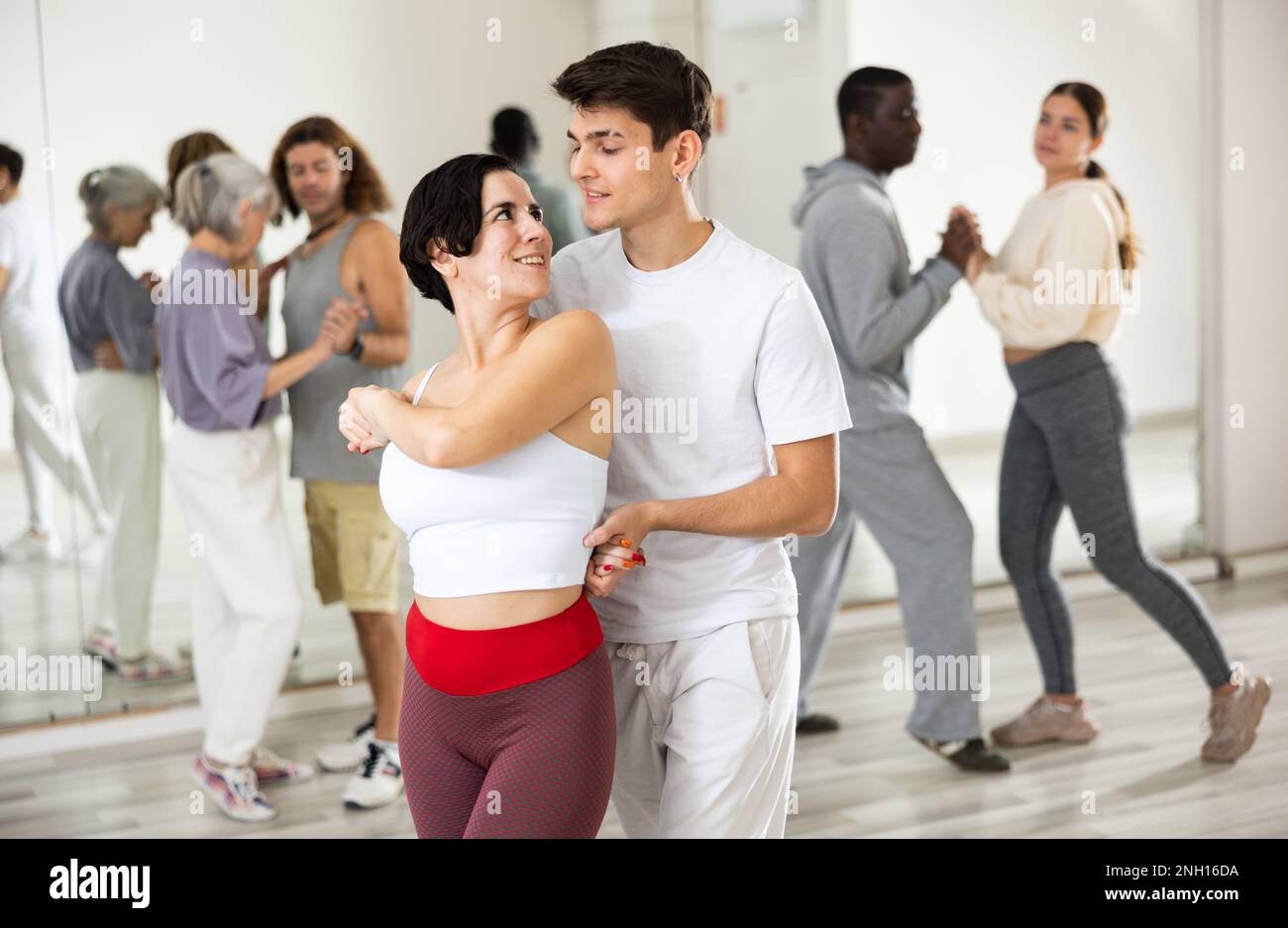 Dancing positive couples learning salsa Stock Photo - Alamy