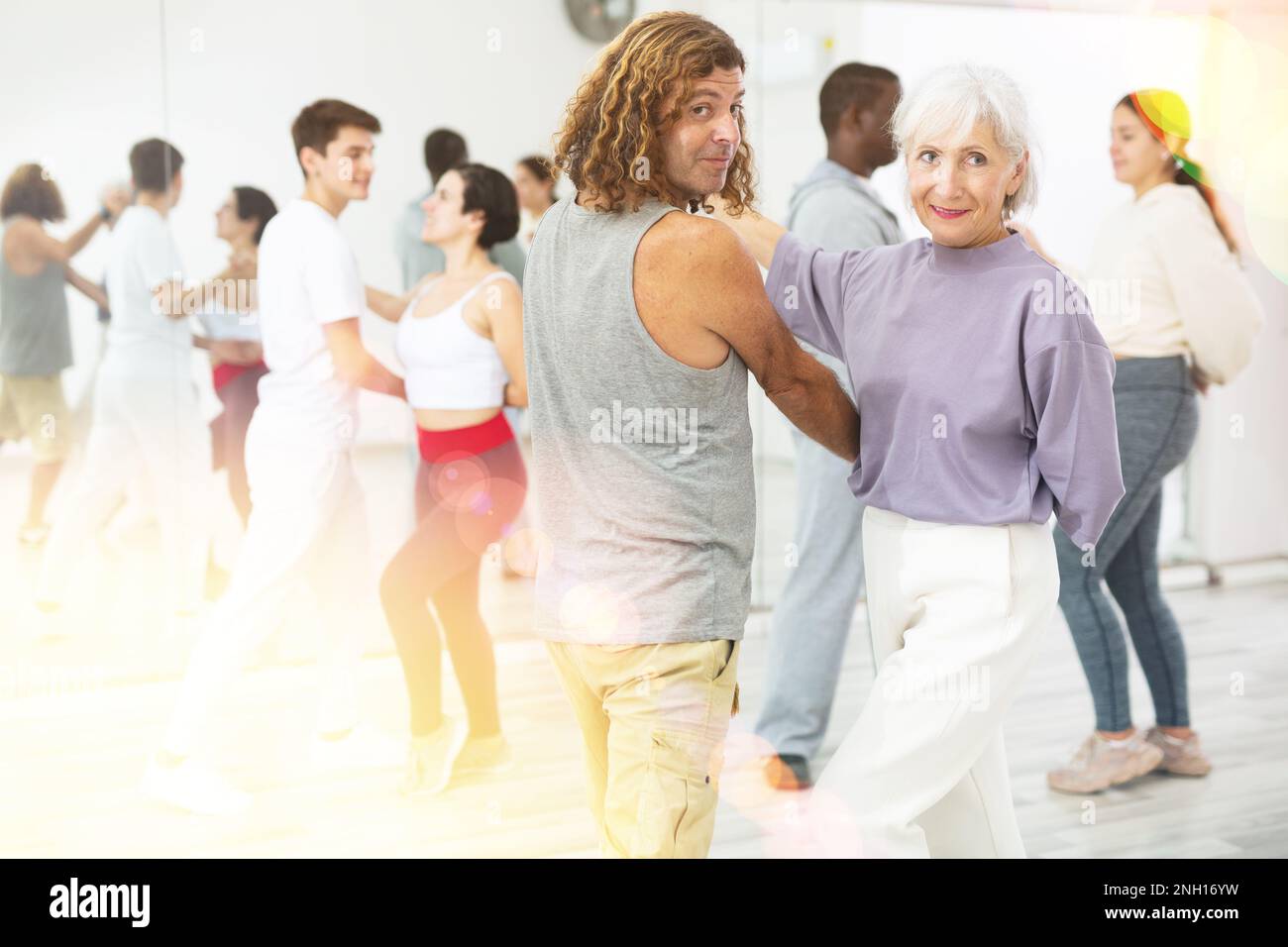 Dancing positive couples learning salsa Stock Photo - Alamy