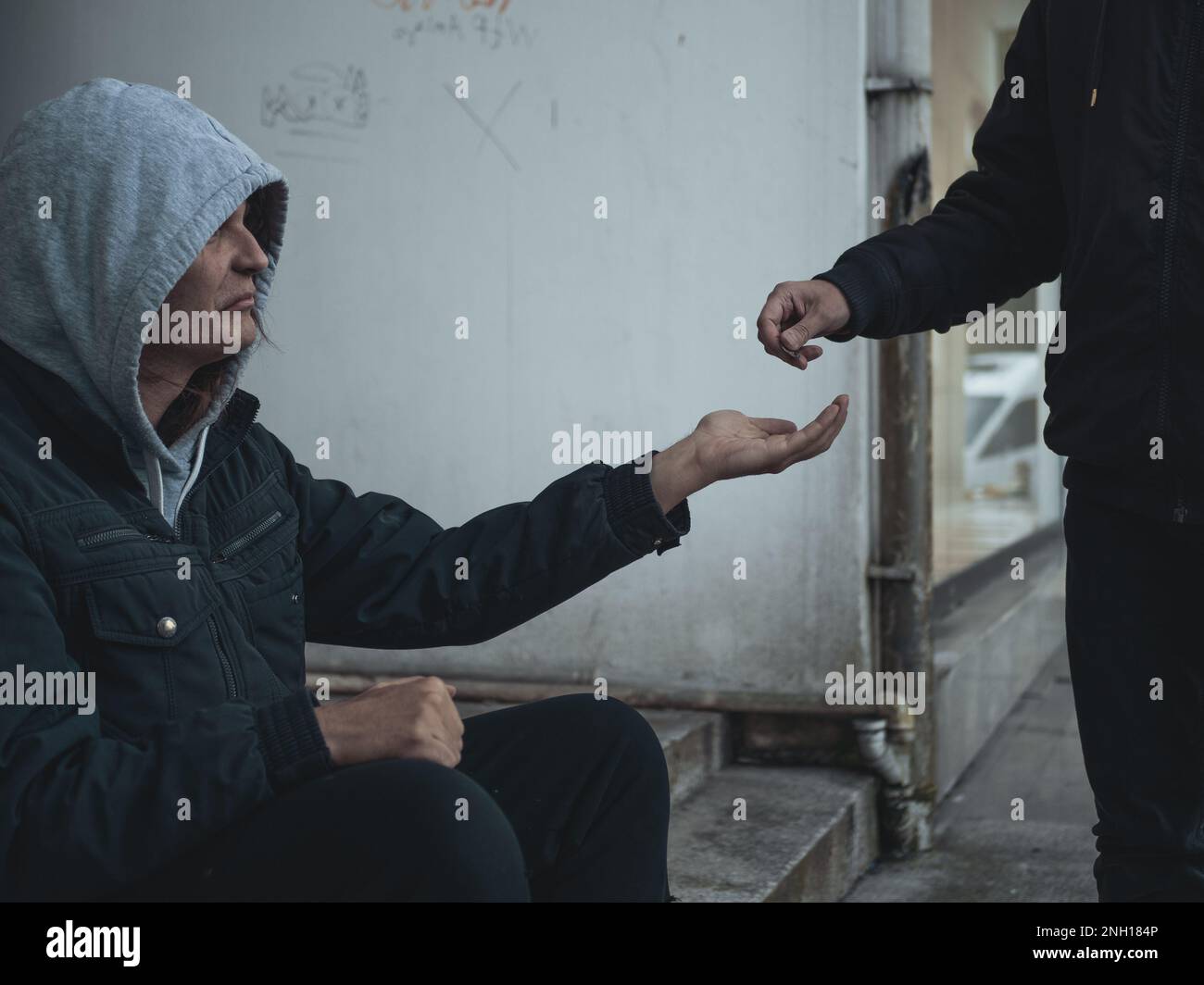 Homeless man sits on steps and asks for help and money Stock Photo - Alamy