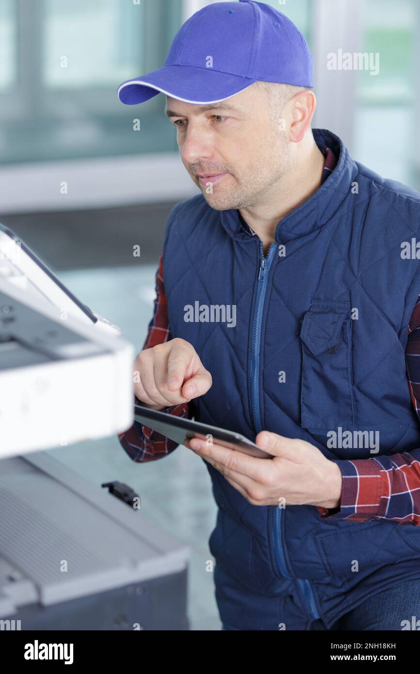 male technician repairing digital photocopier machine Stock Photo - Alamy