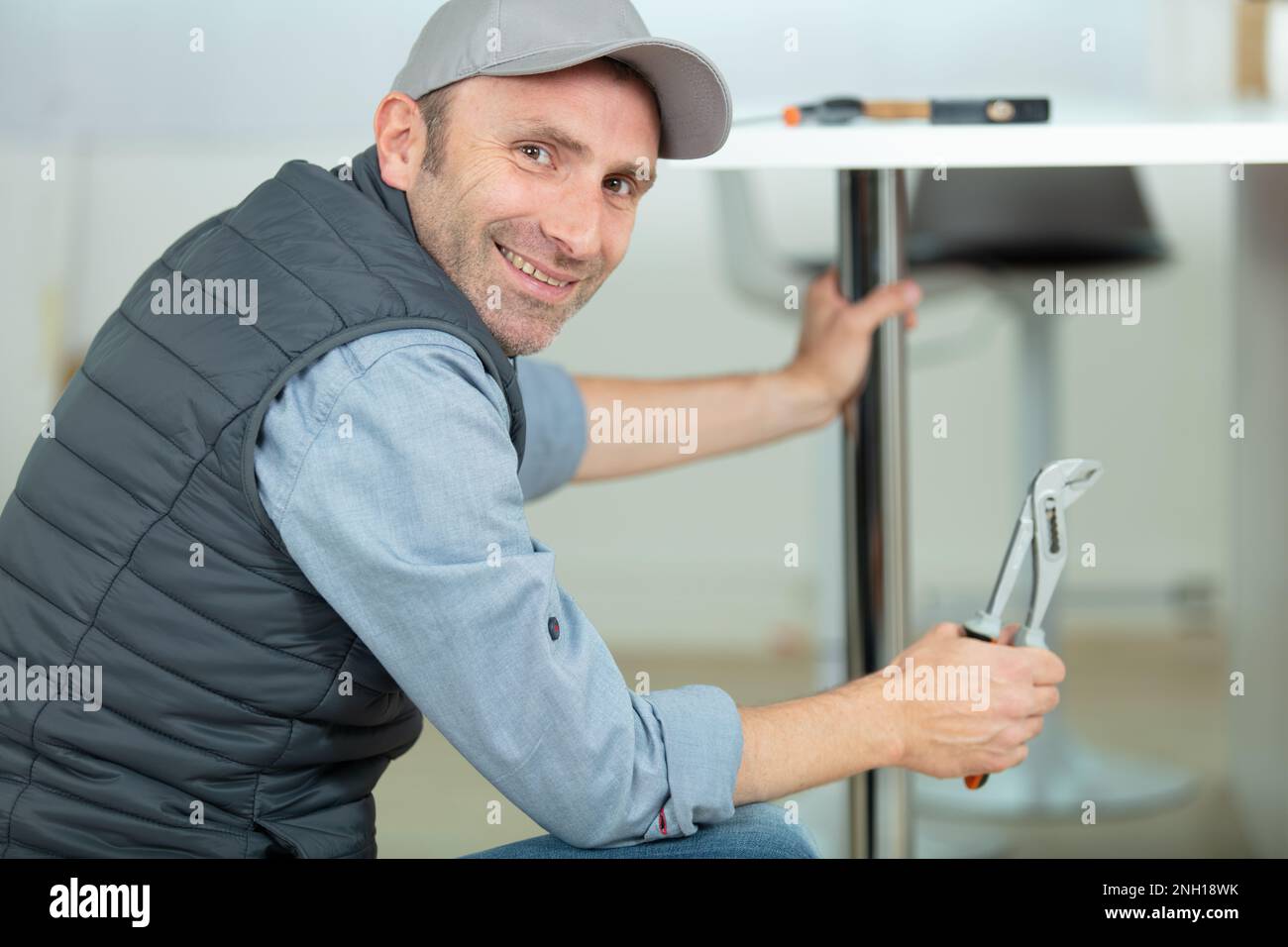 man fixing the leg of the table Stock Photo - Alamy