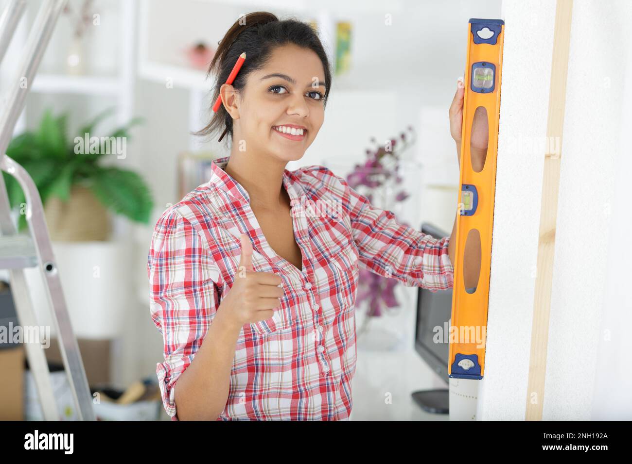 woman using spirit level holding thumbs-up Stock Photo - Alamy