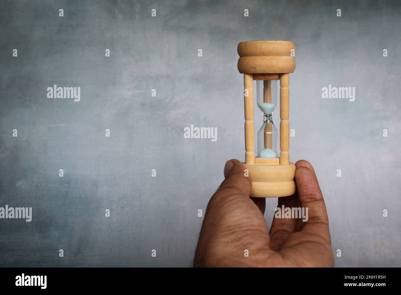 Closeup image of hand holding sand hourglass with copy space. Countdown ...