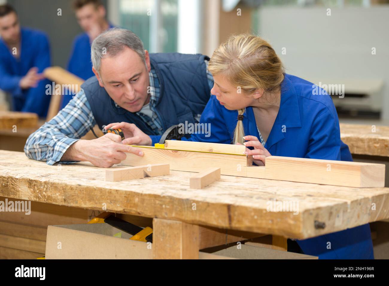 carpenter teaching apprentice how to cut wood Stock Photo - Alamy