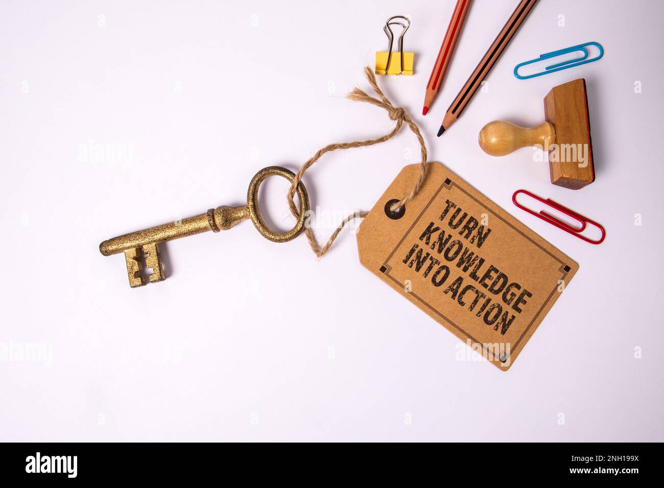 Turn Knowledge Into Action. Gold key with price tag Stock Photo - Alamy
