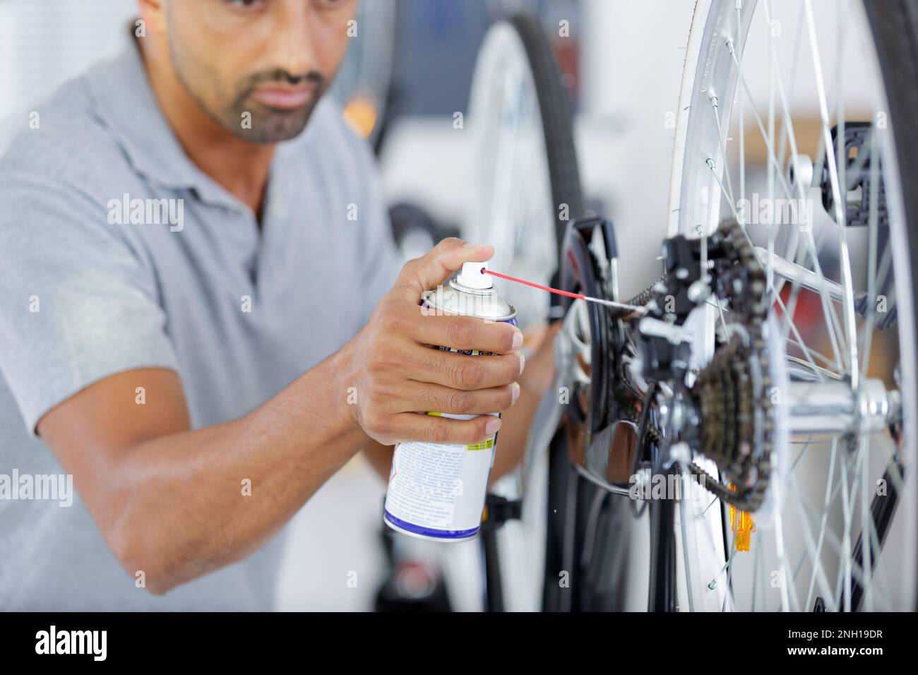man oiling a bicycle chain and gear with oil spray Stock Photo - Alamy