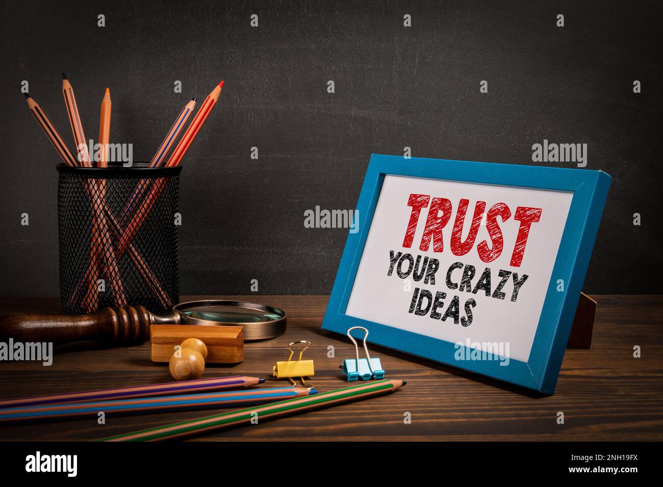 Trust Your Crazy Ideas. Motivational quote. Picture frame on the office ...