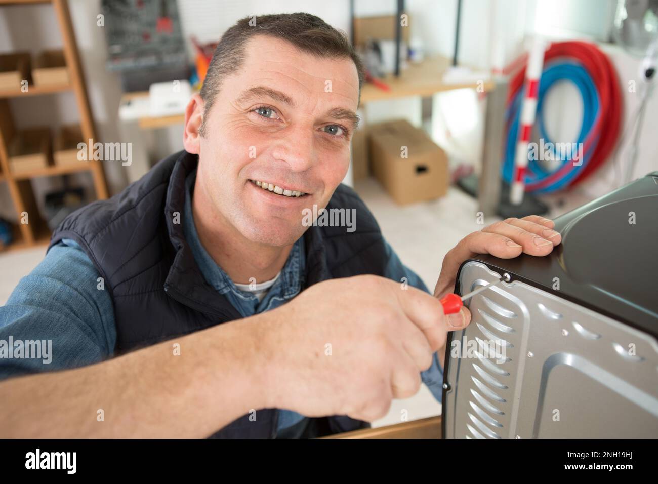a man fitting a new oven in kitchen Stock Photo - Alamy