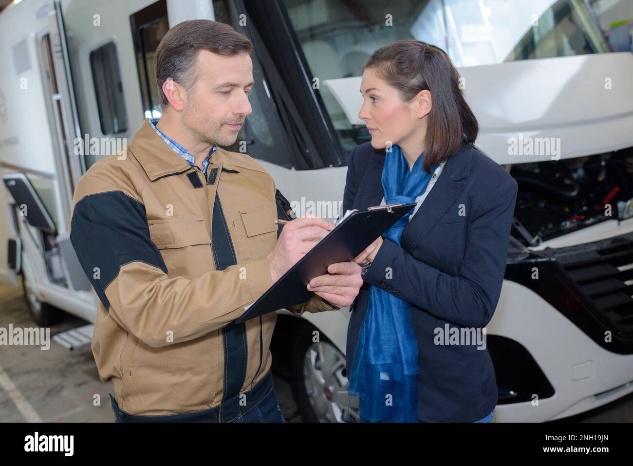camper van mechanic signing on the clipboard Stock Photo - Alamy
