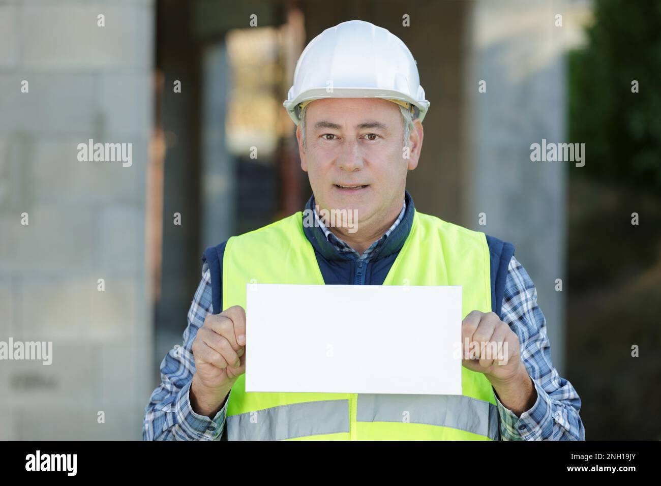 construction worker holding blank advertising banner Stock Photo - Alamy