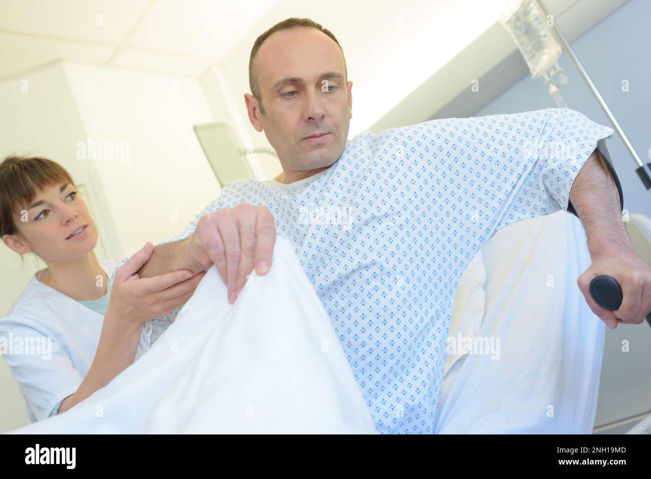 male patient getting out of bed Stock Photo - Alamy