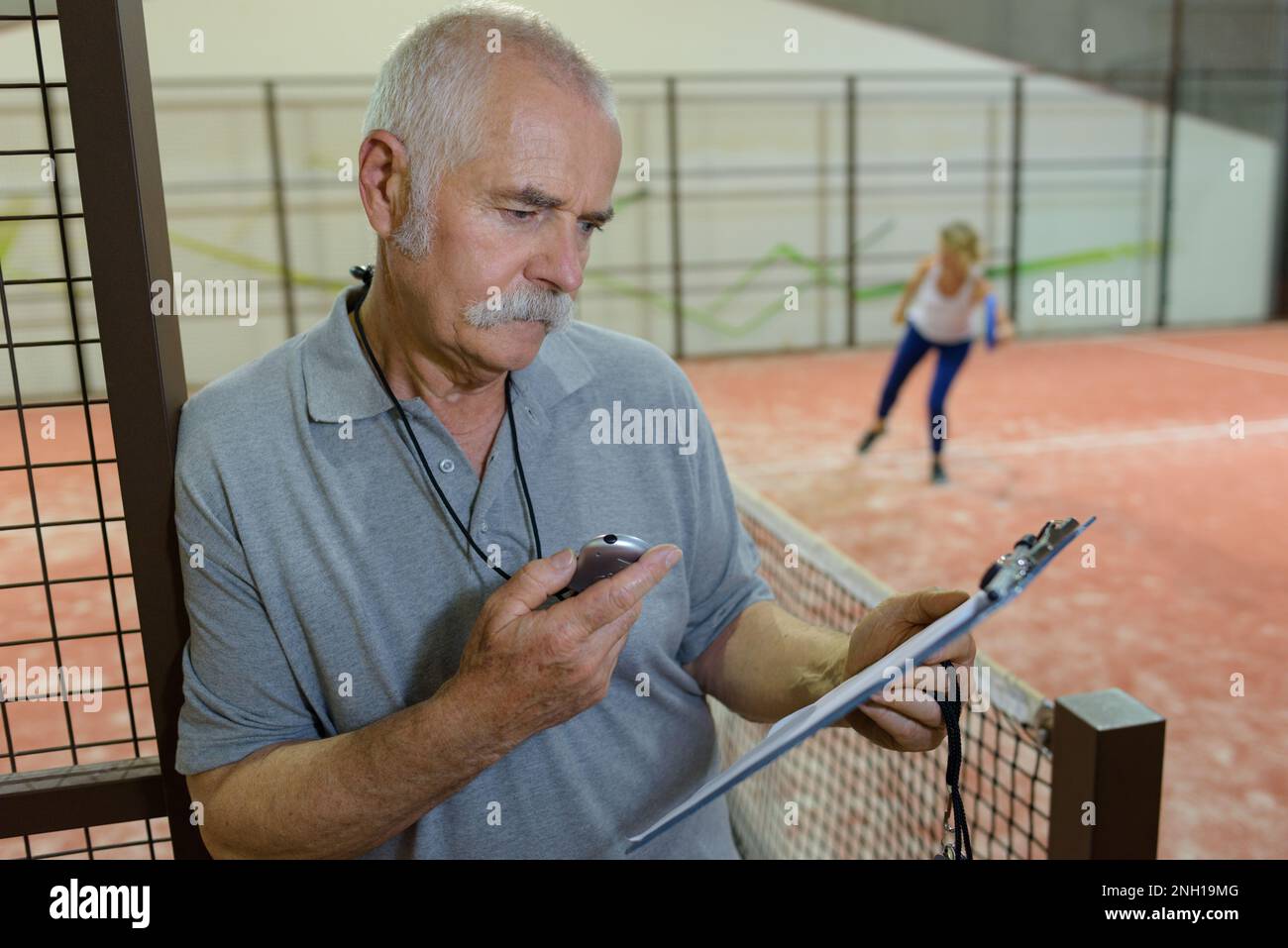 senior male trainer with clipboard and stopwatch Stock Photo - Alamy