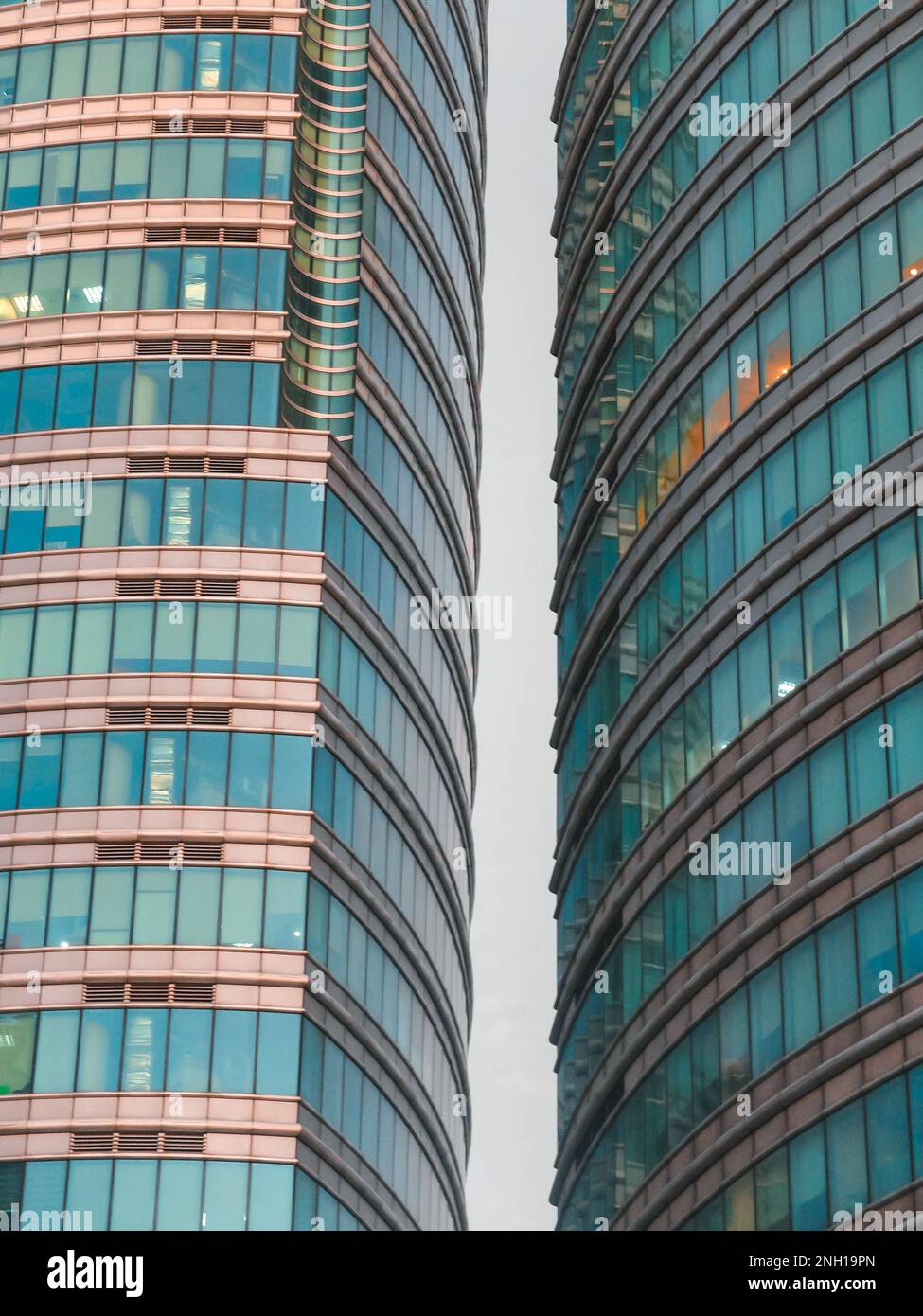 Two high-rise buildings constructed with glass materials, illuminated ...