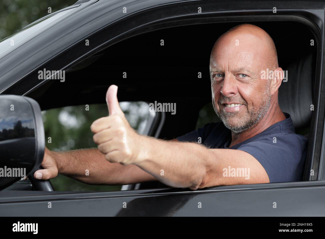 happy mature male motorist giving a thumbs up Stock Photo - Alamy
