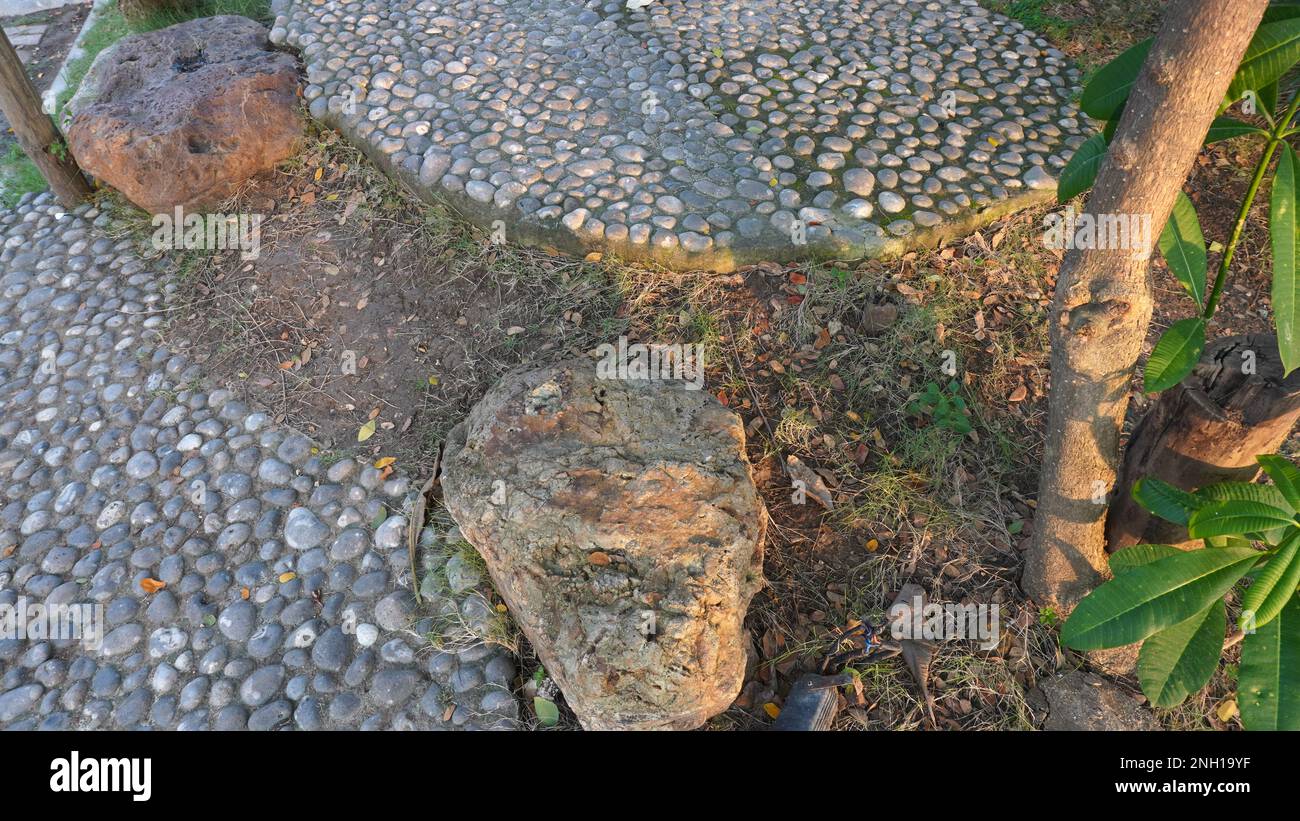 Neatly arranged and organized stones next to the garden pond can be ...