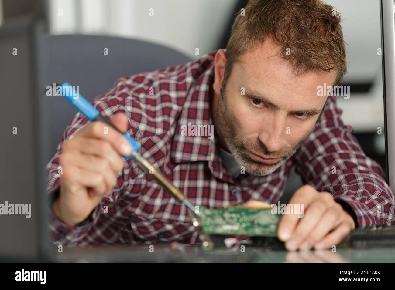 male technician soldering a computer component Stock Photo - Alamy