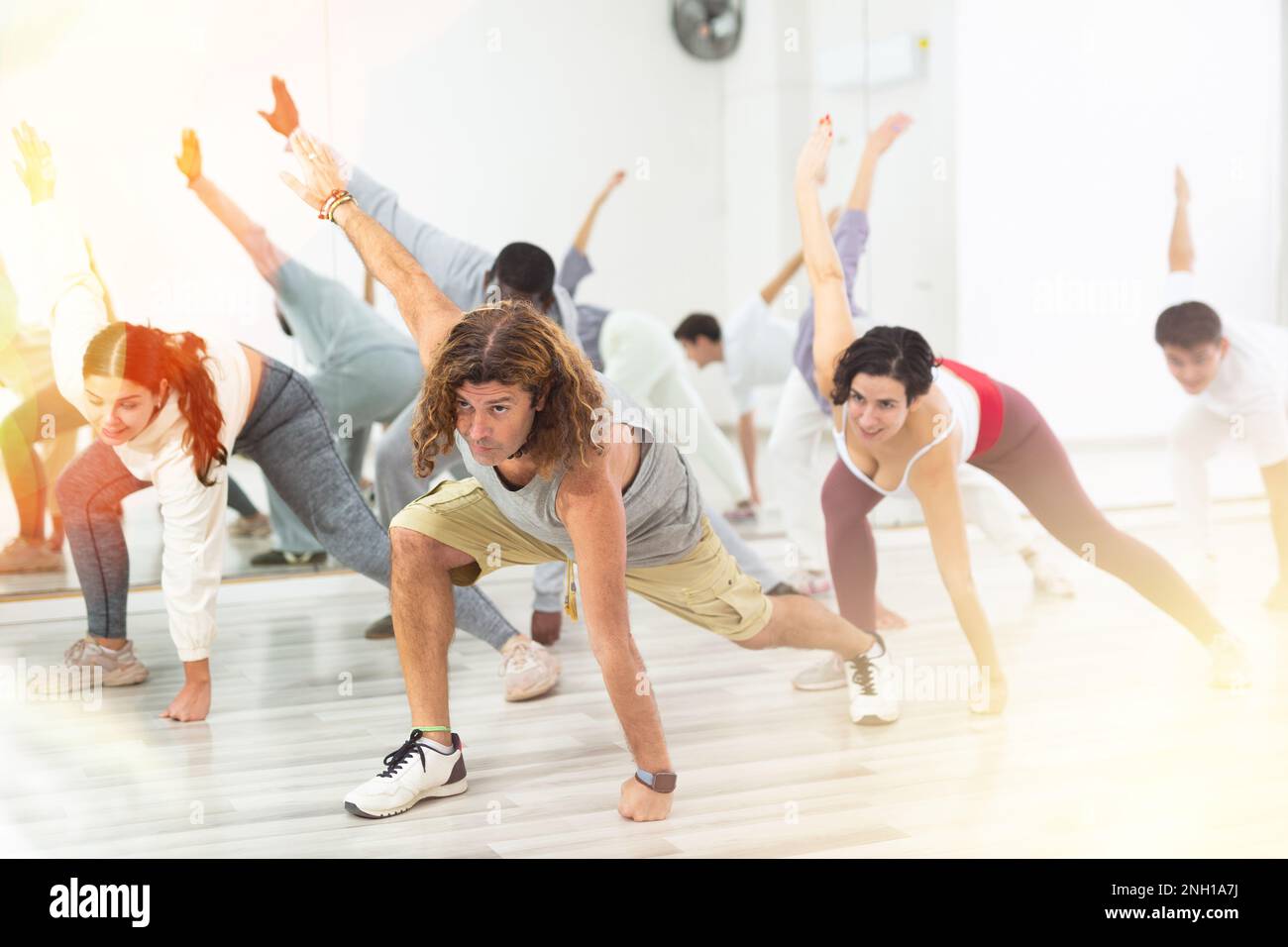 Group of active people performing a stretching exercise Stock Photo - Alamy