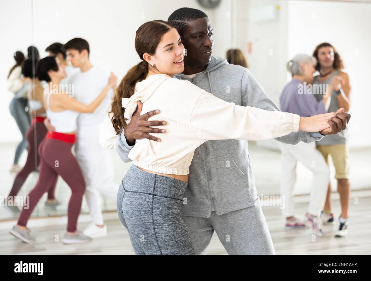 African man and caucasian lady rehearsing latin paired dance moves ...