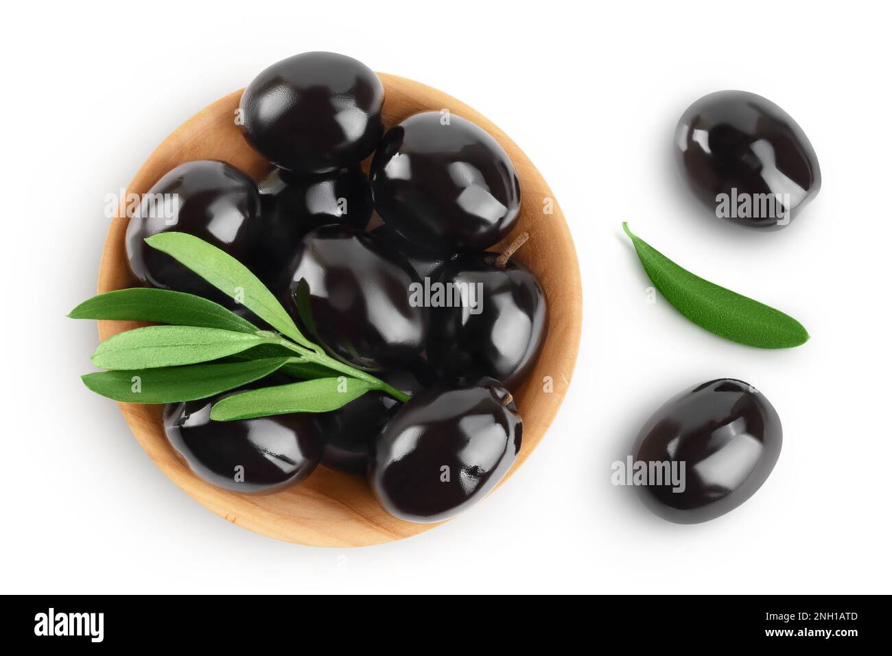 Black olives with leaves in wooden bowl isolated on a white background ...