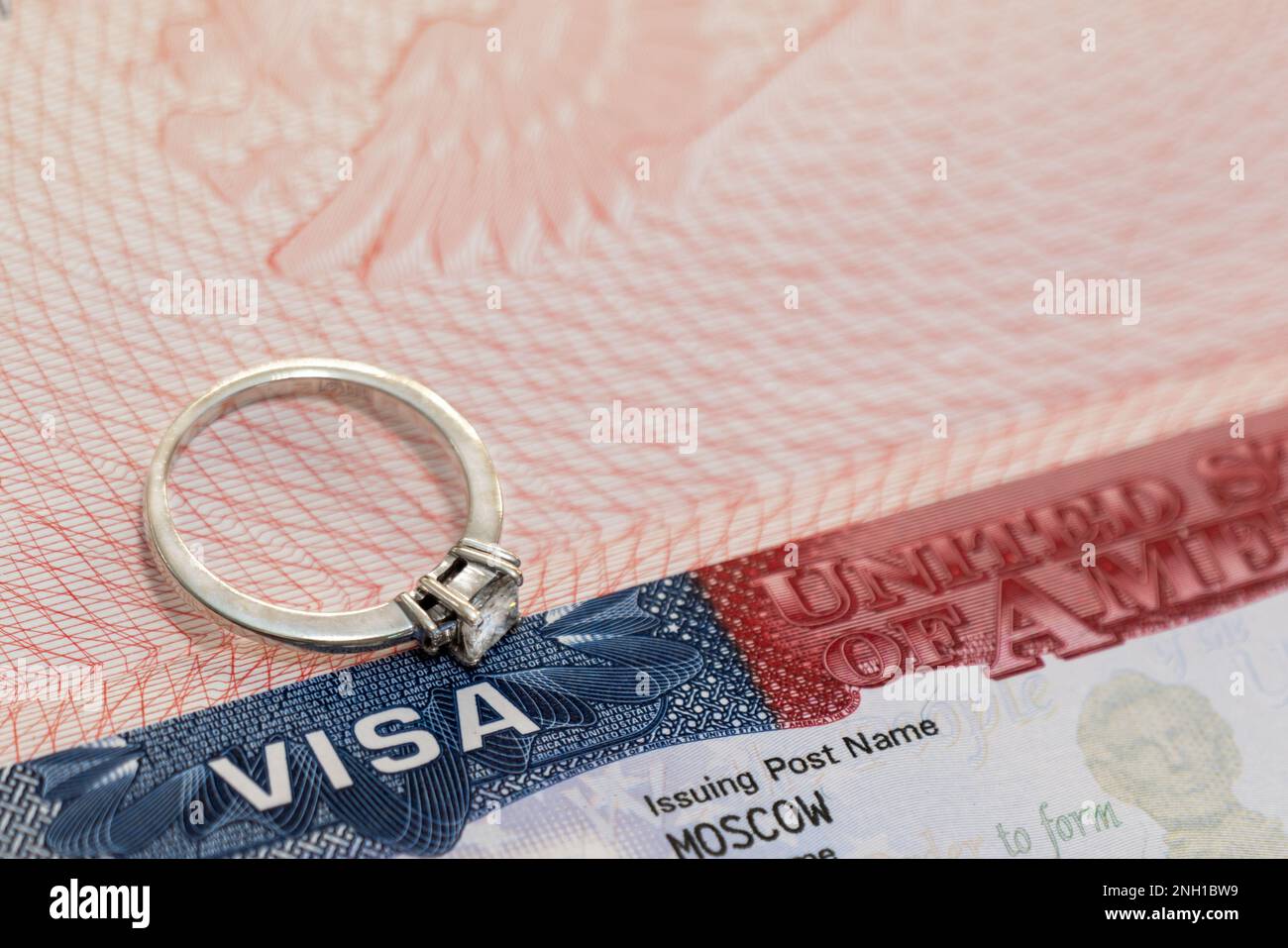 A ring with a precious stone on the background of a US visa as a symbol ...